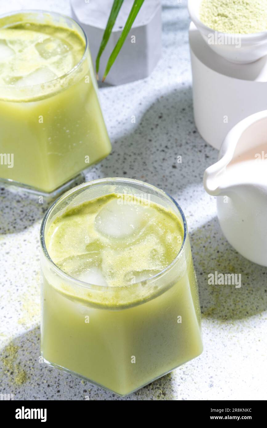 Cold matcha green tea drink. Iced matcha latte cocktail in two glasses ...