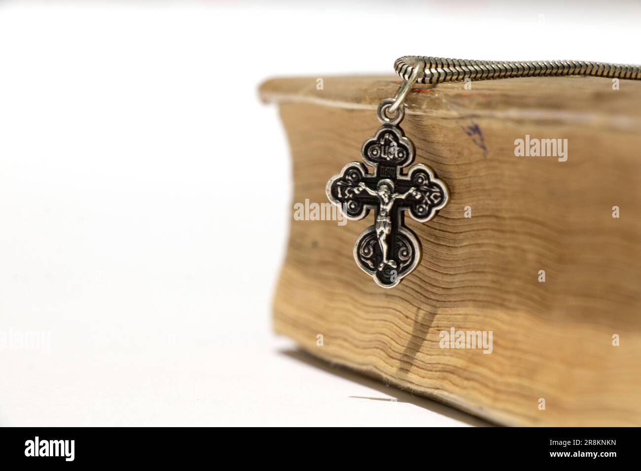 silver christian cross and old book on a white background Stock Photo ...