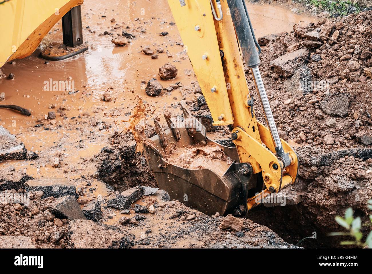 an excavator has dug a hole and is bailing out water after an accident ...