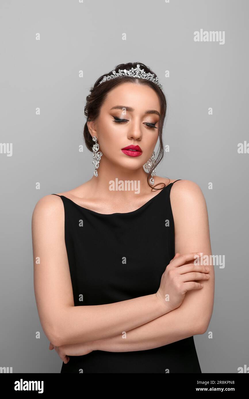 Beautiful young woman wearing luxurious tiara on light grey background Stock Photo - Alamy
