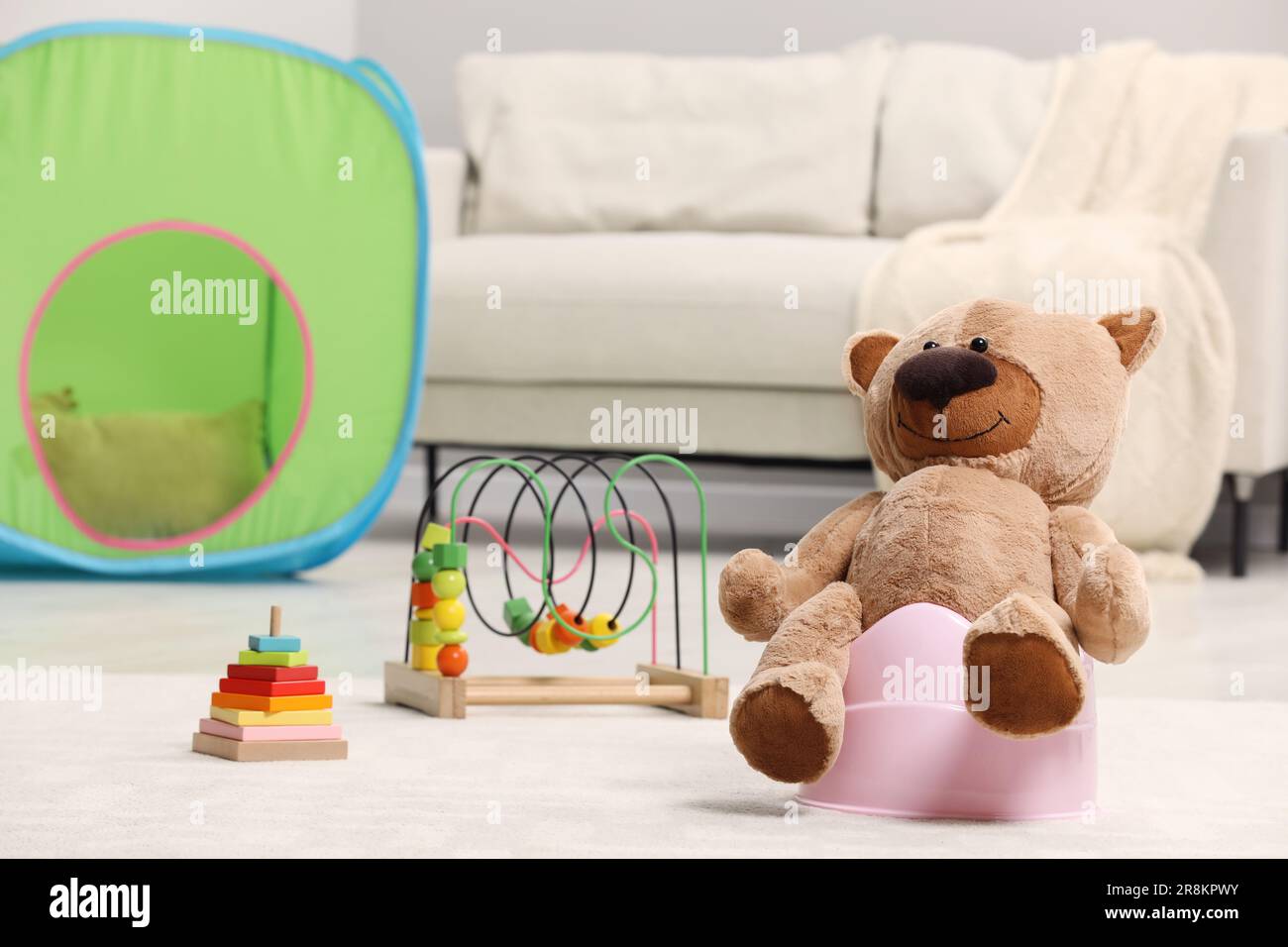 Cute teddy bear on pink baby potty in room. Toilet training Stock Photo ...