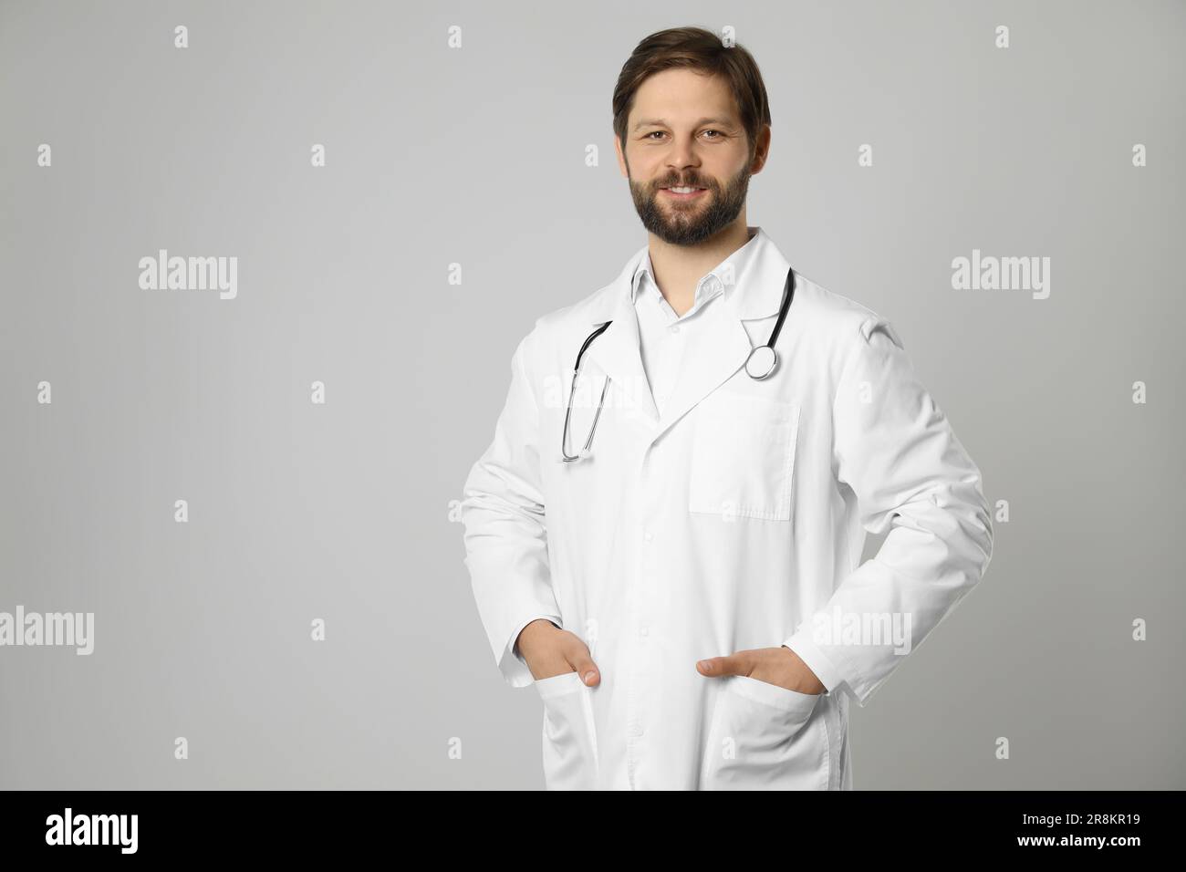 Doctor or medical assistant (male nurse) with stethoscope on light grey ...