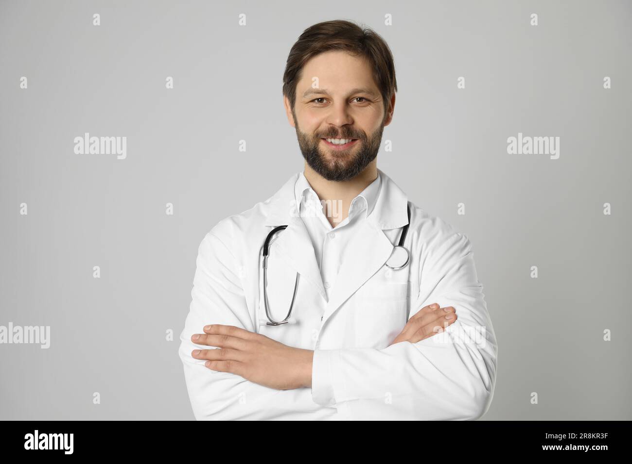 Doctor or medical assistant (male nurse) with stethoscope on light grey ...