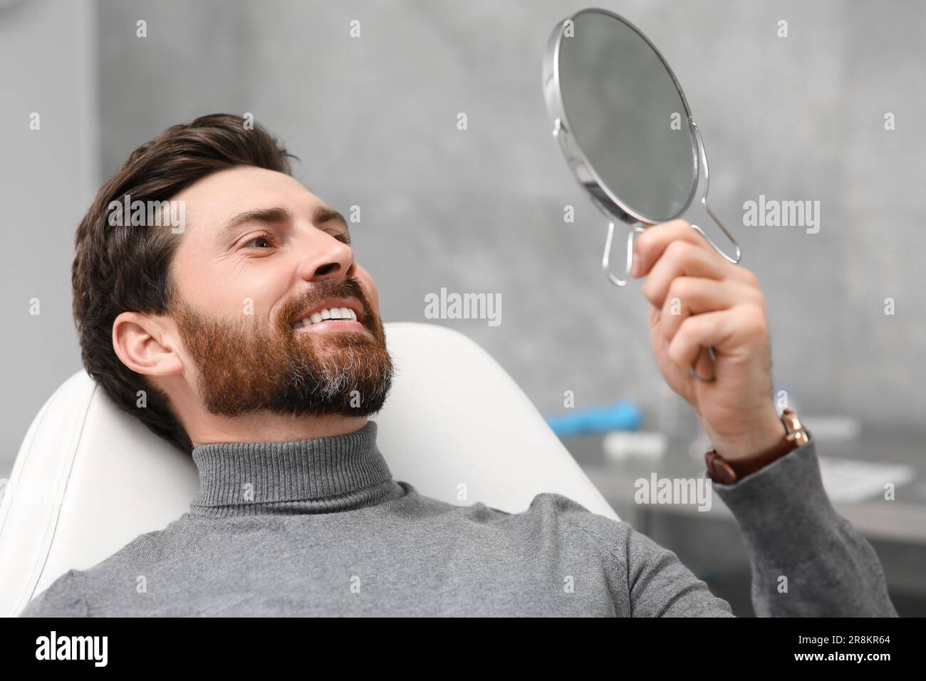 Man looking at his new dental implants in mirror indoors Stock Photo ...