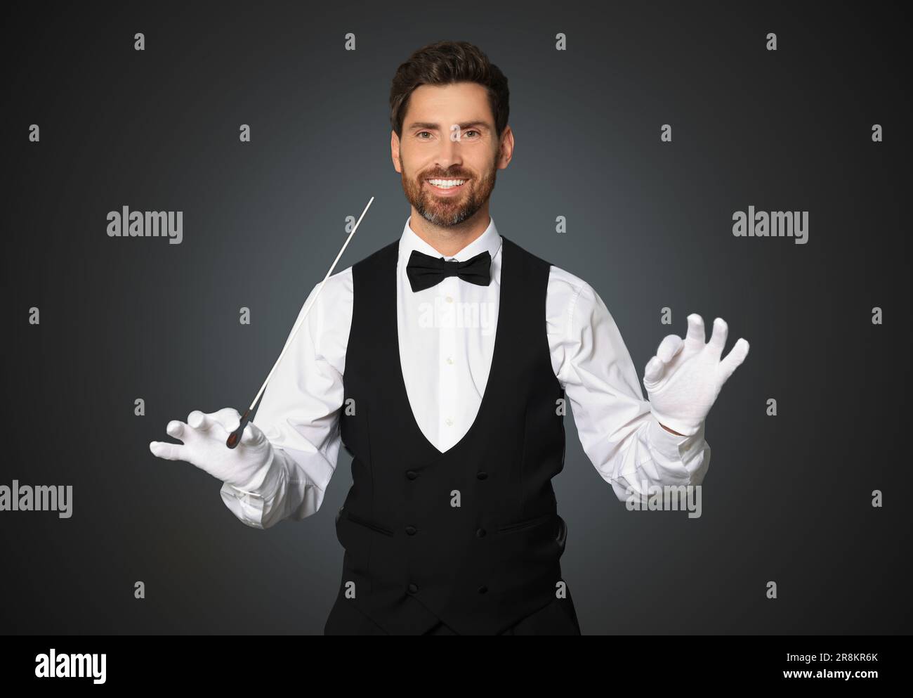 Happy professional conductor with baton on black background Stock Photo ...