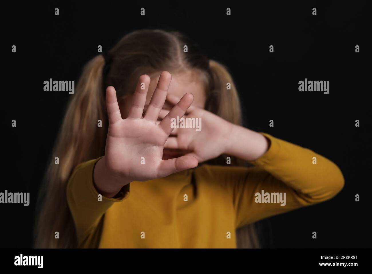 Girl making stop gesture against black background, focus on hands ...