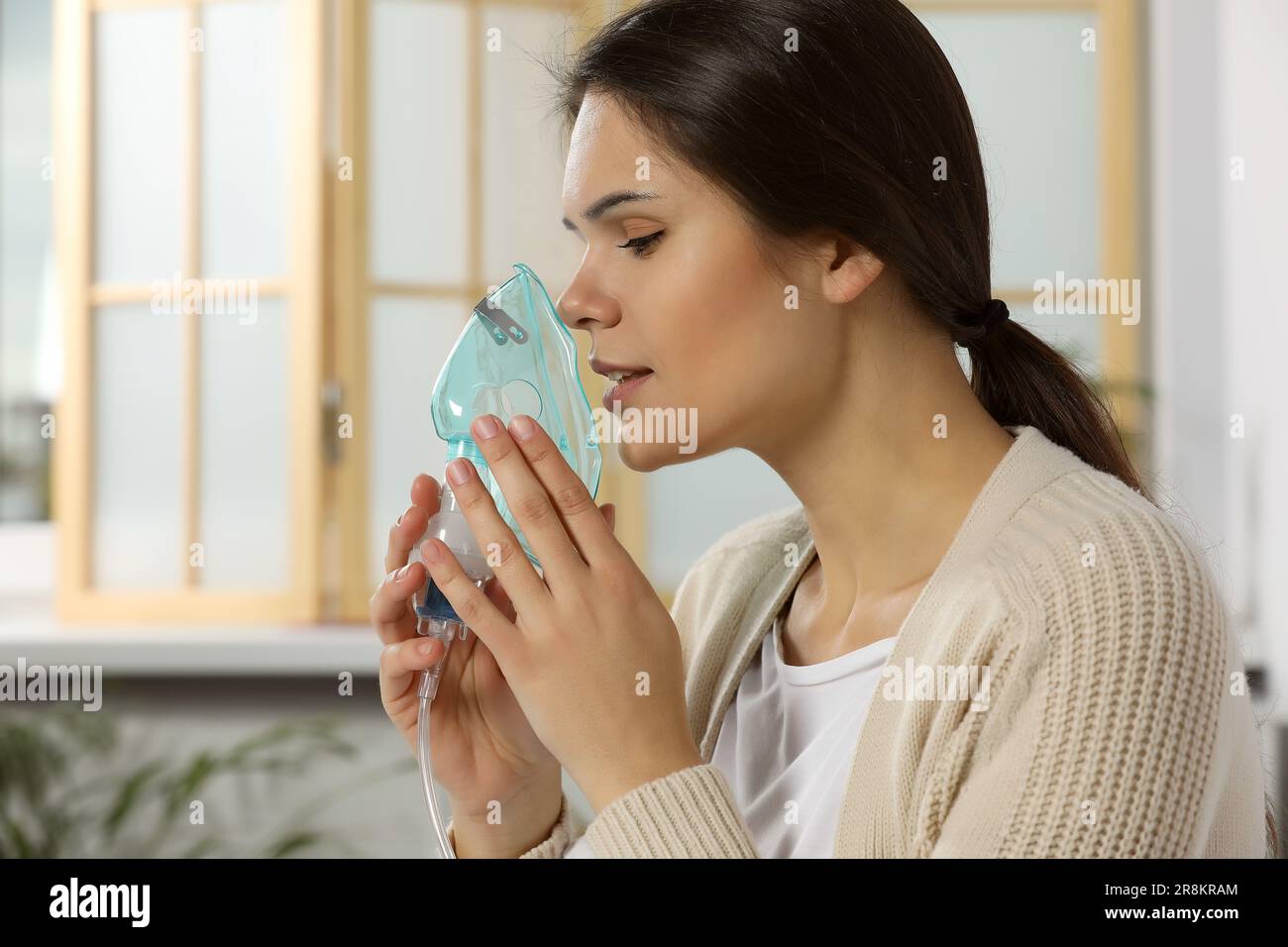 Young girl using aerosol inhaler hi-res stock photography and images ...