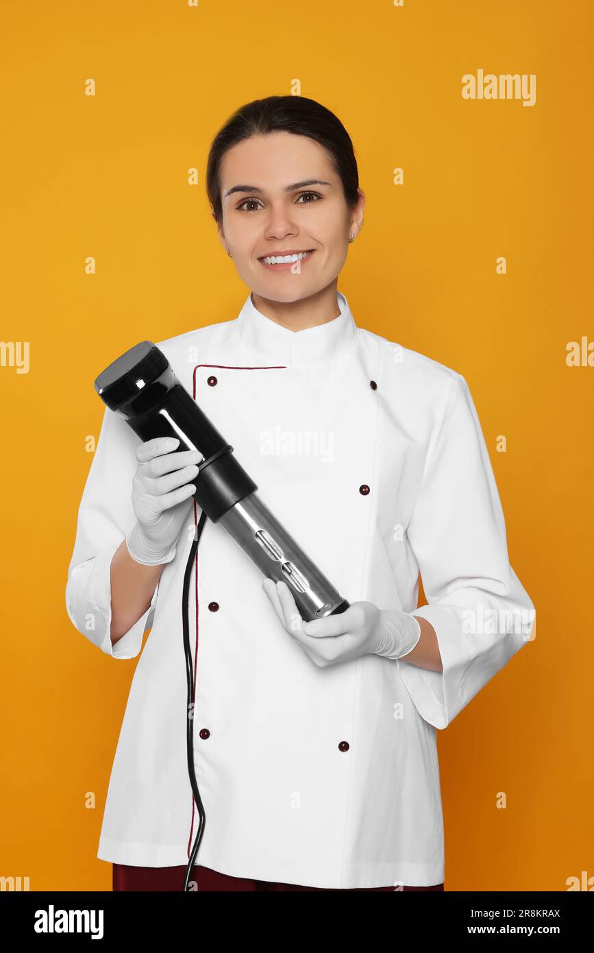 Chef holding sous vide cooker on orange background Stock Photo - Alamy