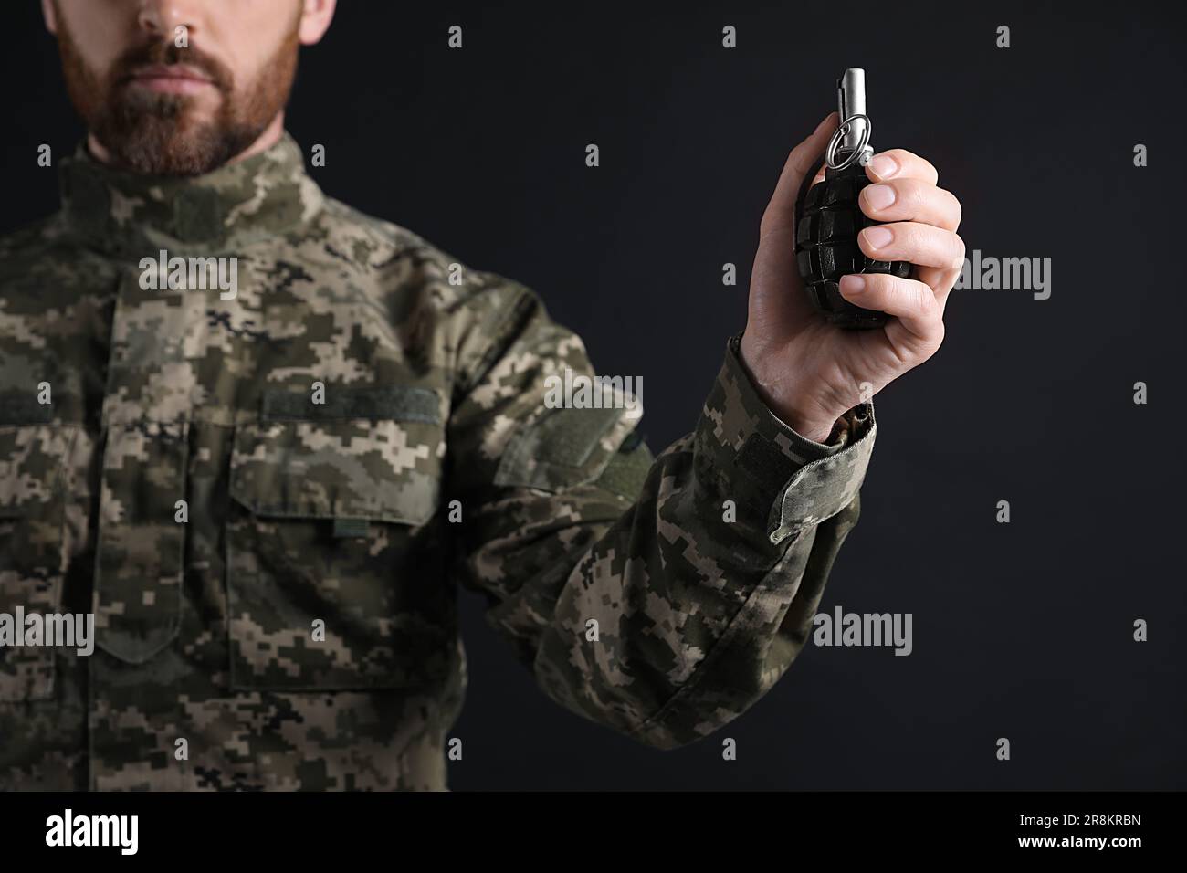 Soldier holding hand grenade on black background, closeup. Military ...