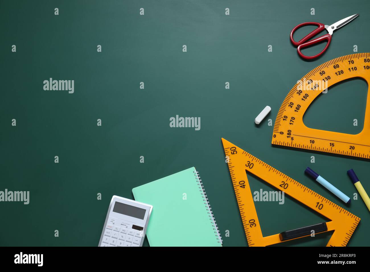 Flat lay composition with protractor, triangle and stationery on green ...