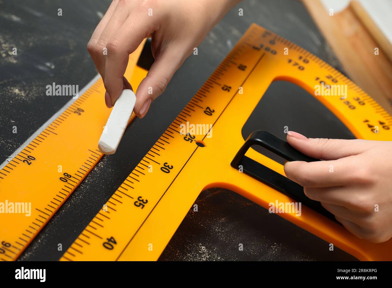 Woman drawing with chalk, ruler and protractor on blackboard, closeup ...