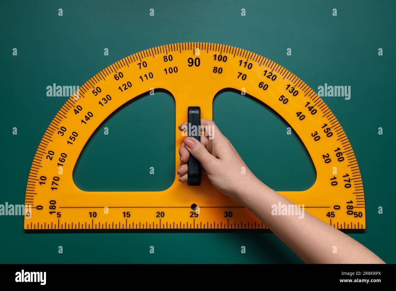 Woman holding protractor with measuring length and degrees markings ...