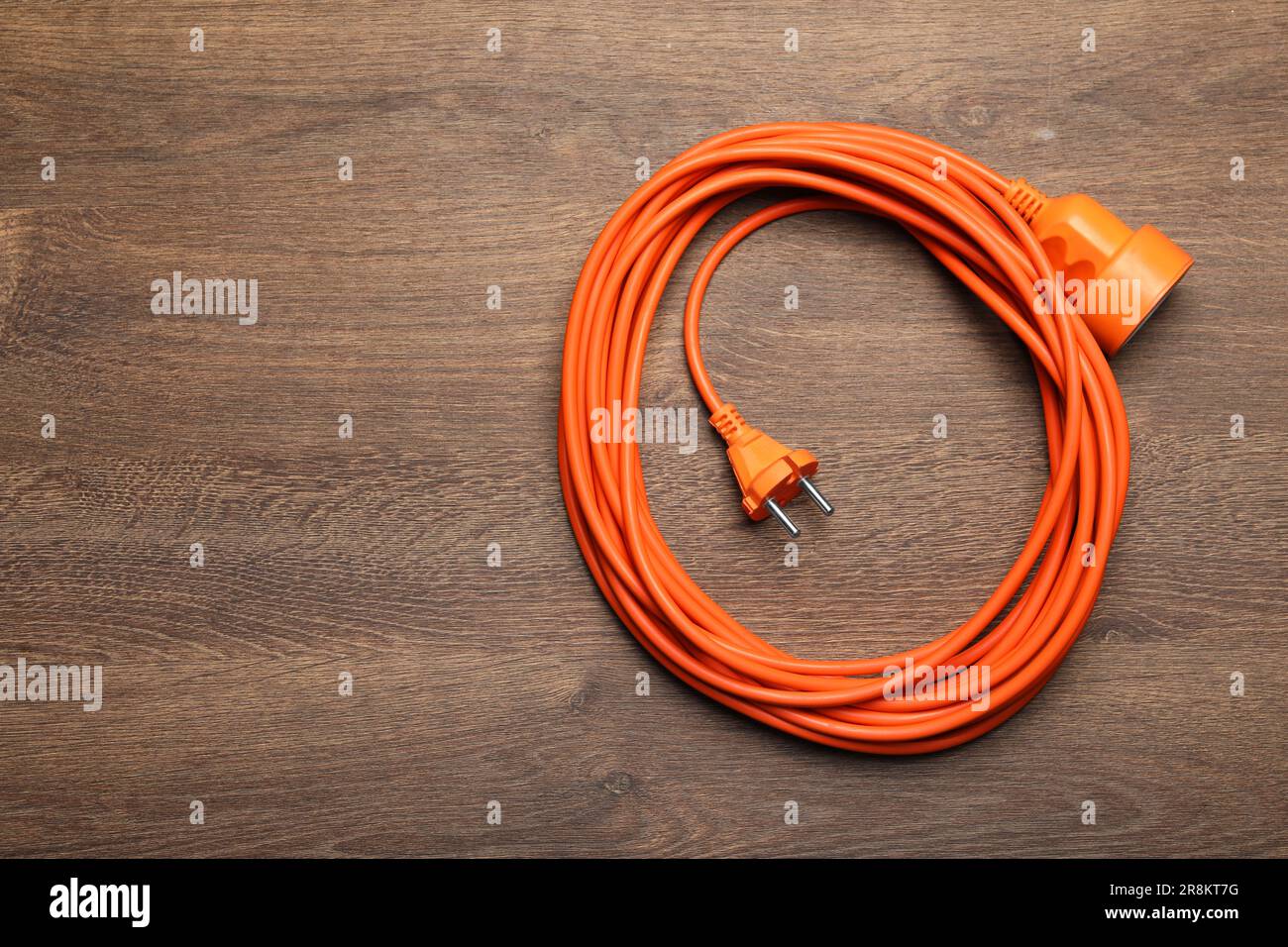 Extension cord on wooden floor, top view. Space for text Stock Photo ...
