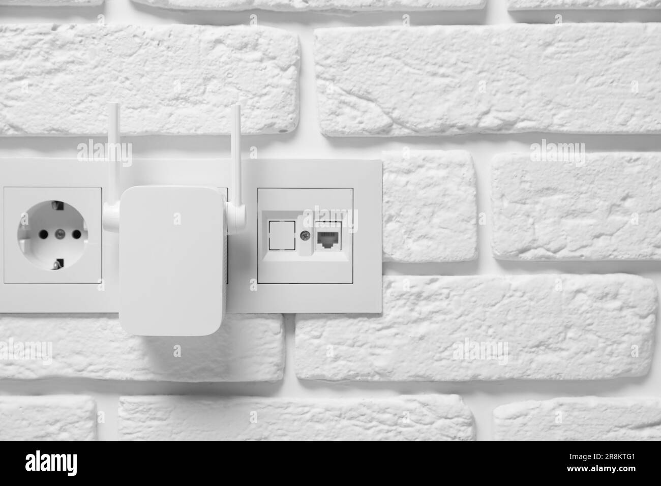 Wireless Wi-Fi repeater on white brick wall, space for text Stock Photo ...