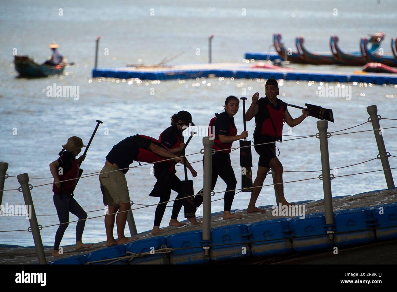 Crew members carry paddles as walk out of the boat during a traditional ...