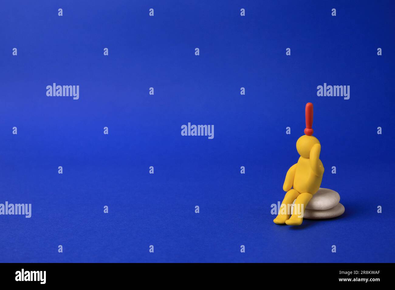 Human figure made of yellow plasticine with exclamation mark as ...