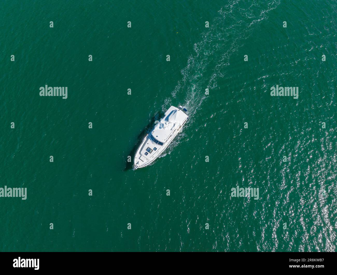 Aerial view of a cabin cruiser along on a calm turquoise ocean at ...