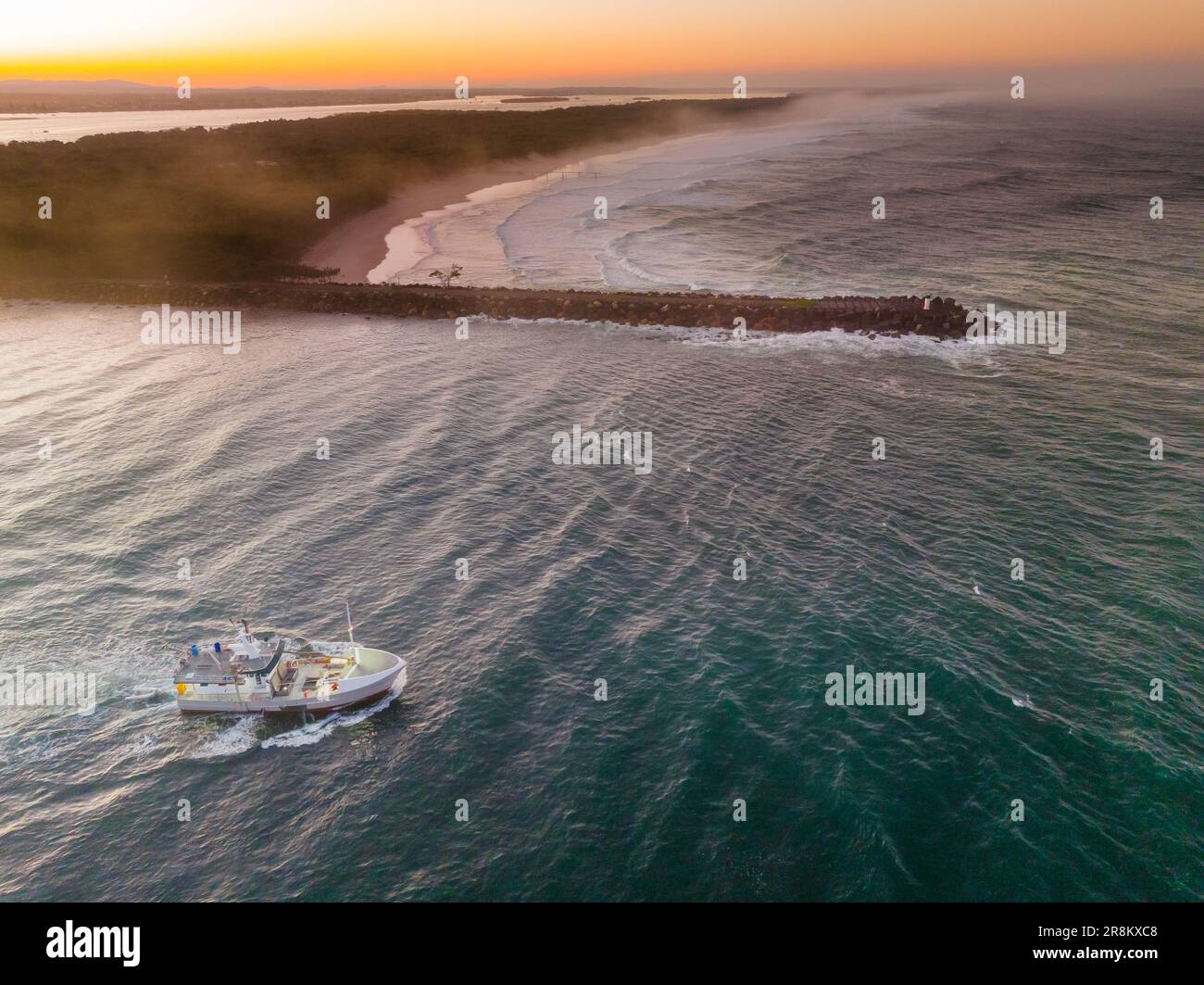 Aerial view of a fishing trawler in deep water in front of a misty ...