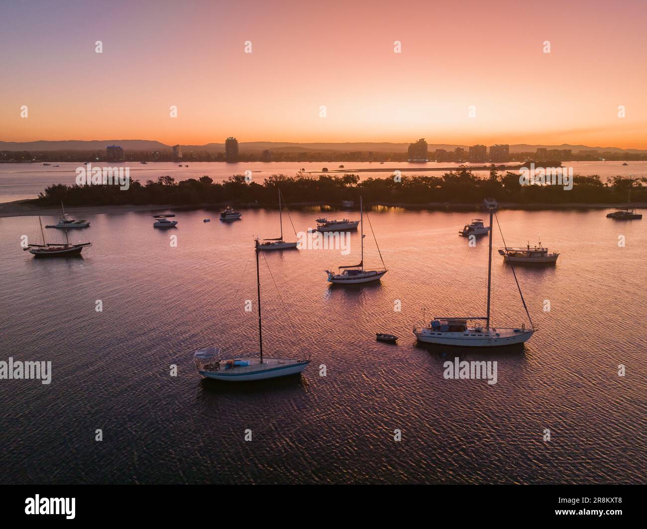 Aerial view of boast and yachts at anchor on a calm bay during twilight ...