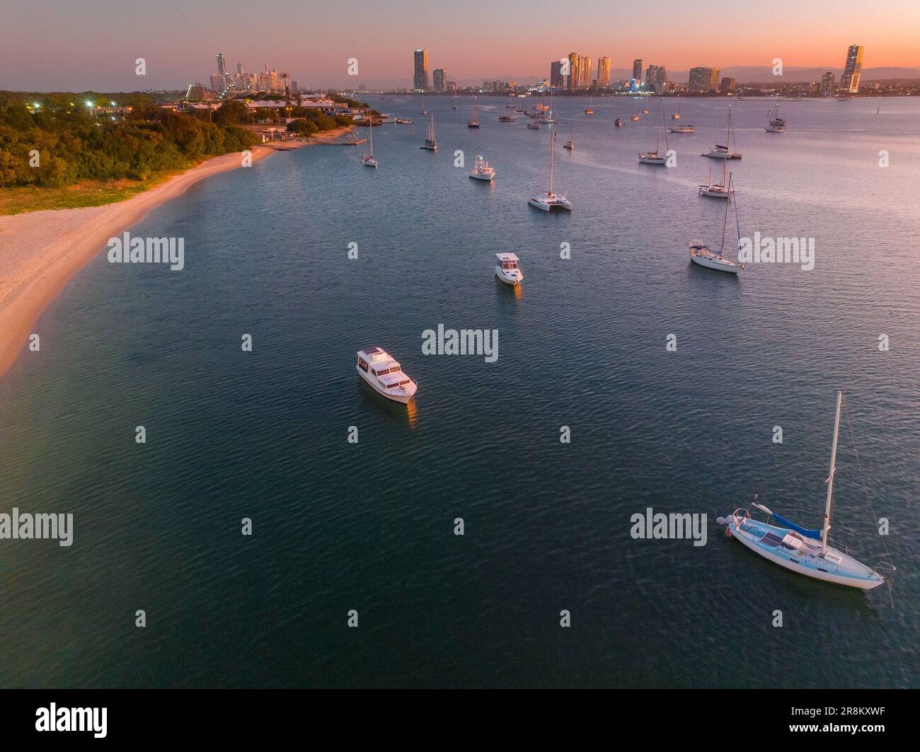 Aerial view of boast and yachts at anchor on a calm bay during twilight ...