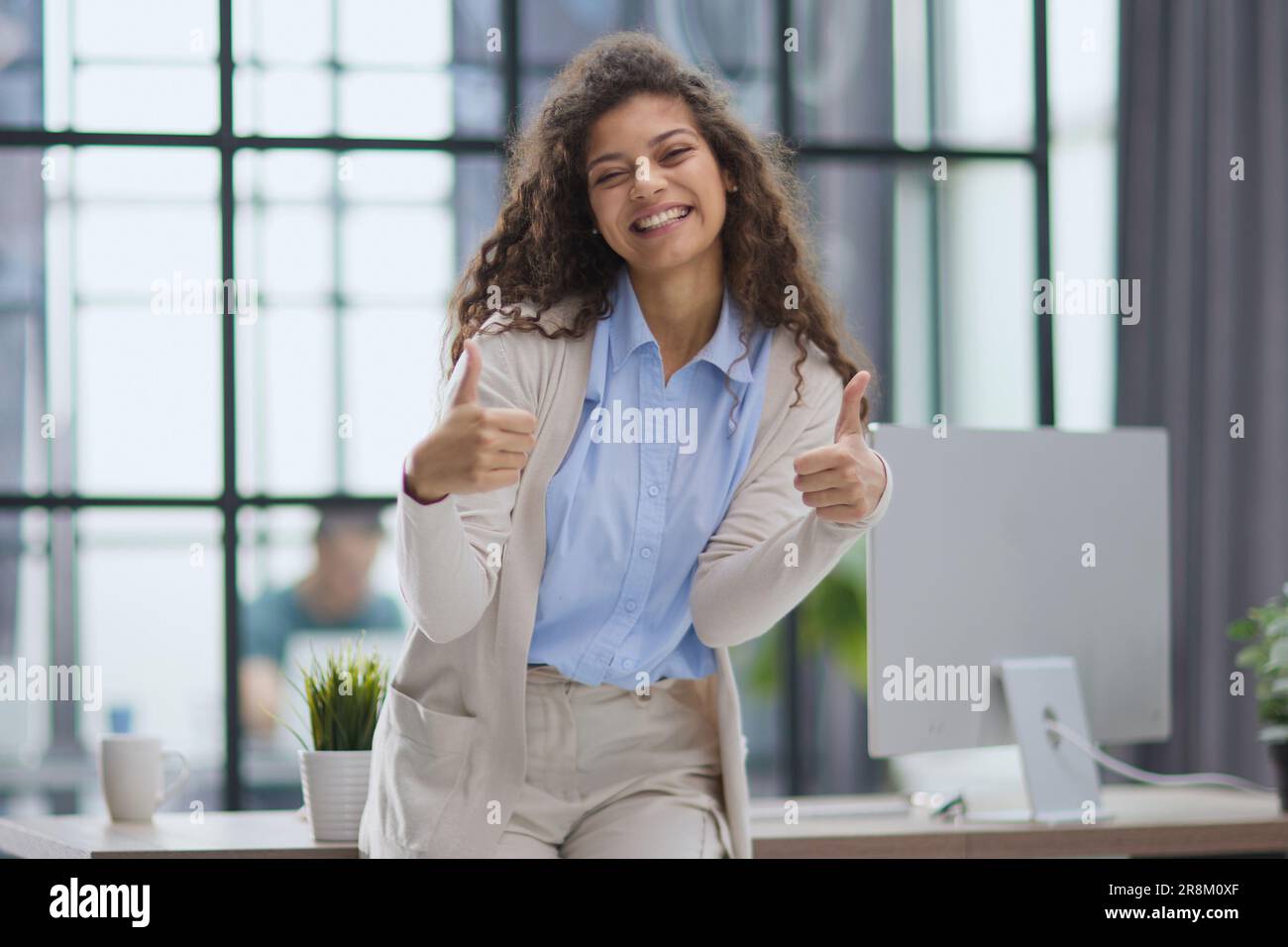 Proud office worker posing with thumbs up Stock Photo - Alamy