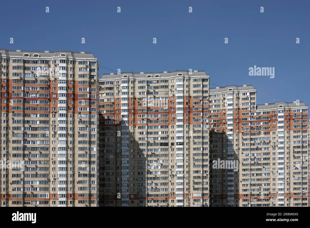 Front view to dense standing residential buildings under clear blue ...