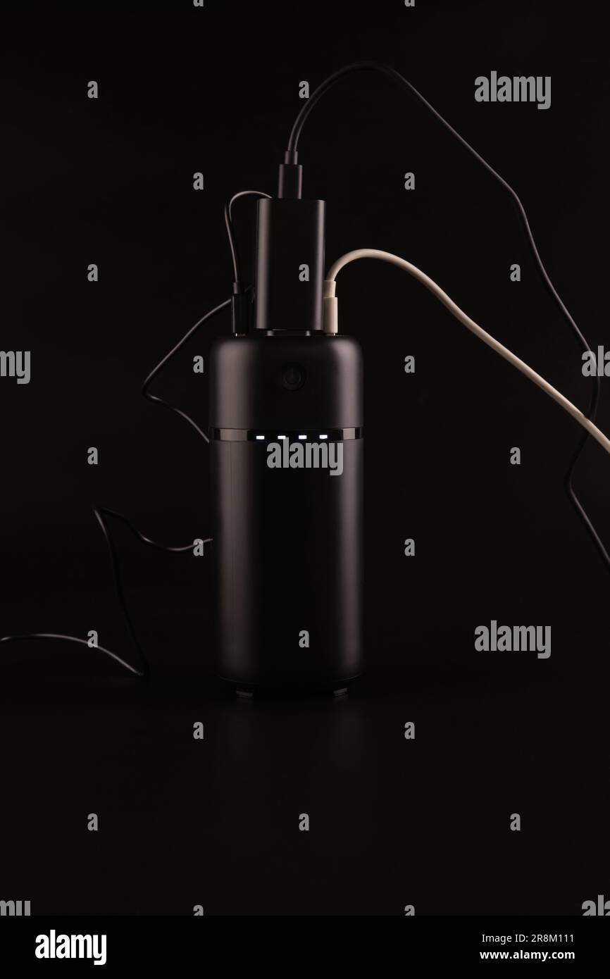 powerbank black on a black background, usb cables, plug, light and ...