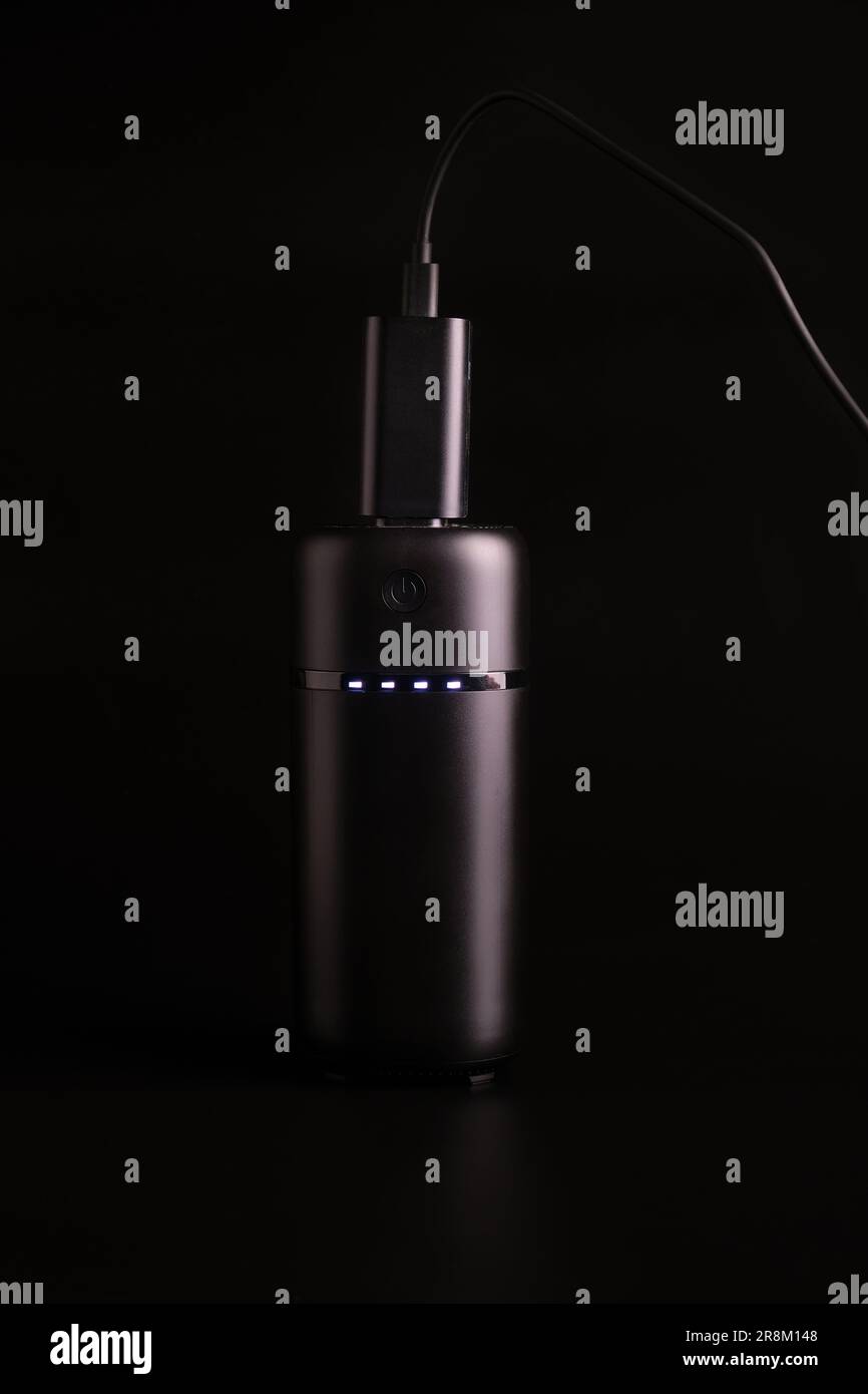 powerbank black on a black background, usb cable, plug, light and ...