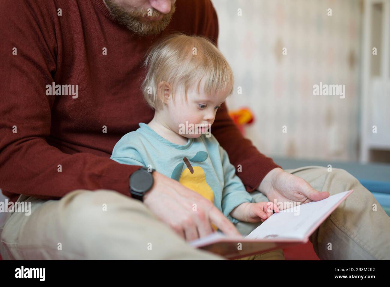 Father reading book to child with down syndrome Stock Photo - Alamy