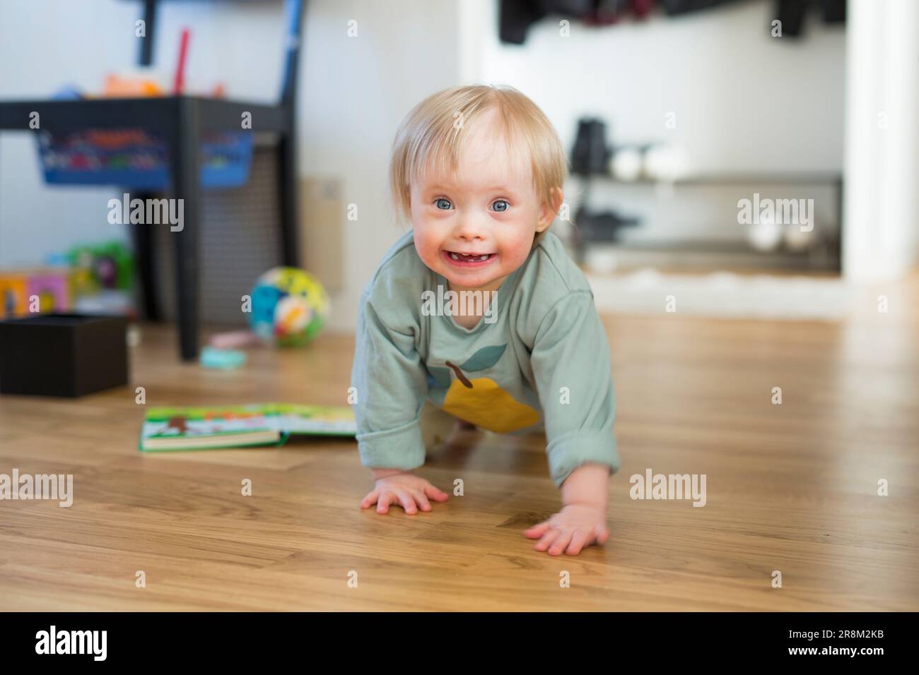 Toddler with down syndrome crawling Stock Photo - Alamy