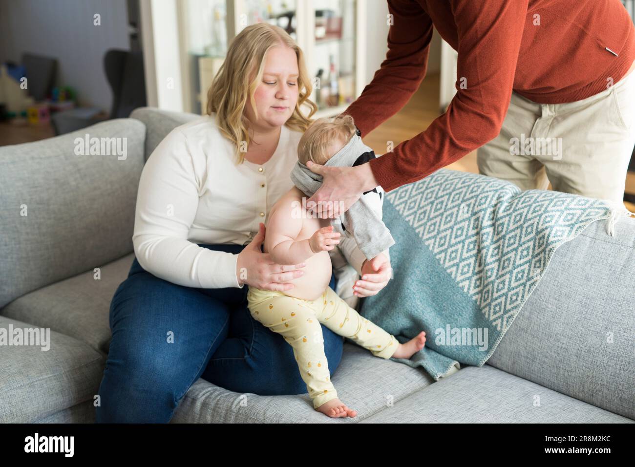 Parents and baby with down syndrome on sofa Stock Photo - Alamy