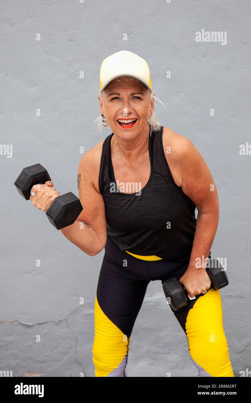 Portrait of fit senior woman with cool haircut wearing sports clothes ...