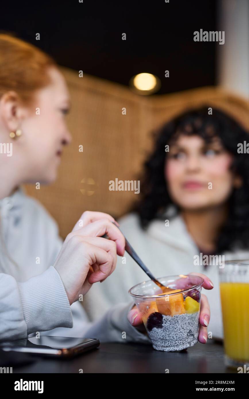 Woman eating fruit dessert in cafe Stock Photo - Alamy