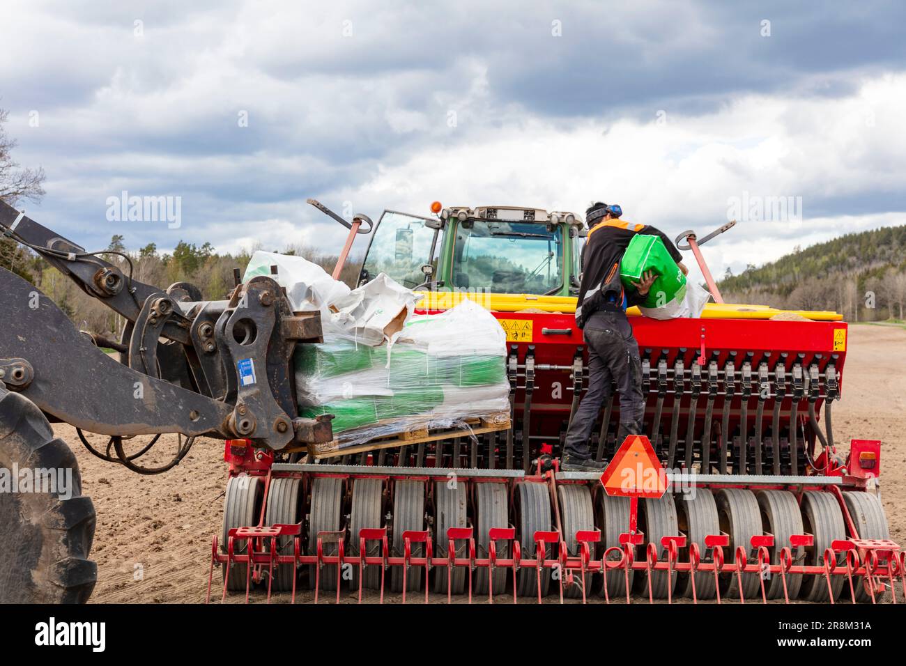 Farm machine working in plowed field Stock Photo - Alamy