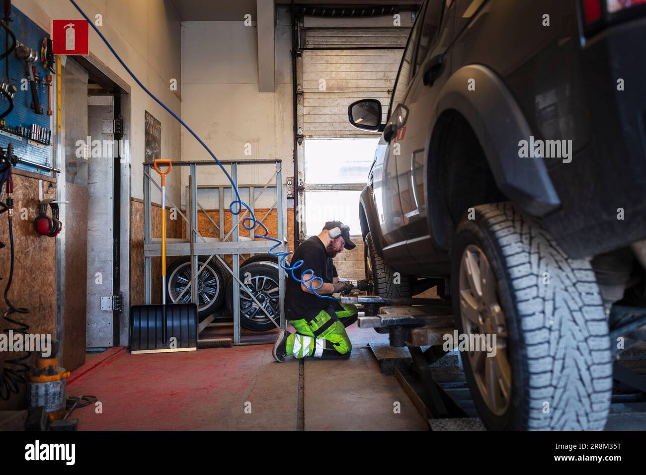 Mechanic in garage repairing car Stock Photo - Alamy