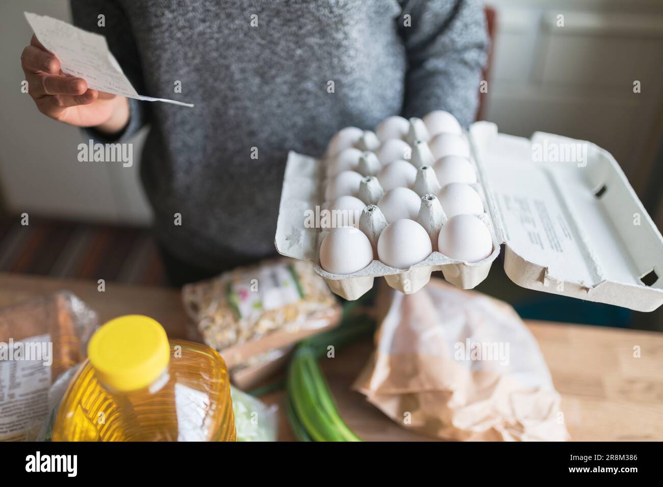 Woman checking receipt from supermarket during inflation with rise in ...