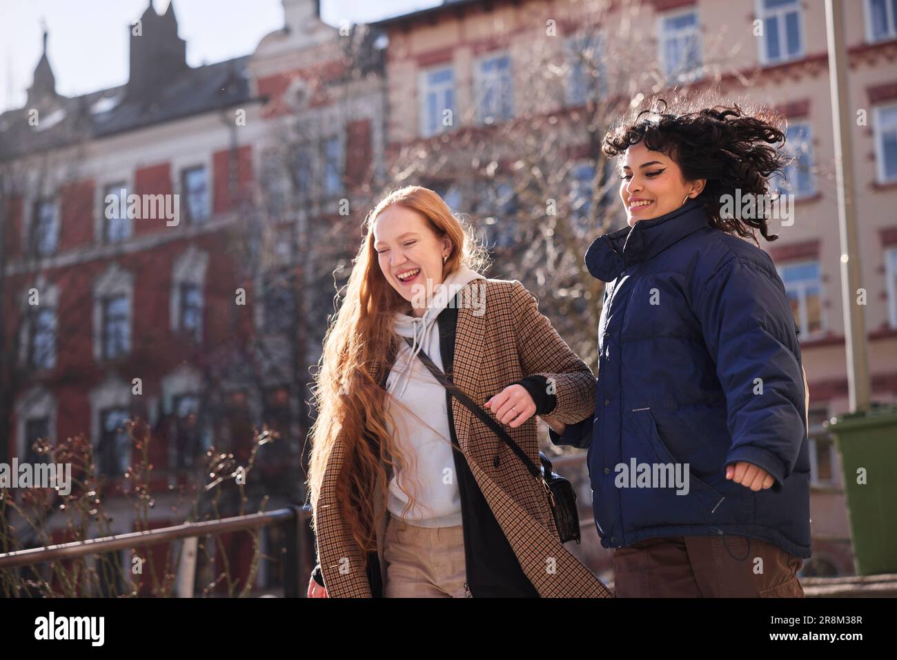 Female friends walking together ourdoors on walkway in city Stock Photo ...
