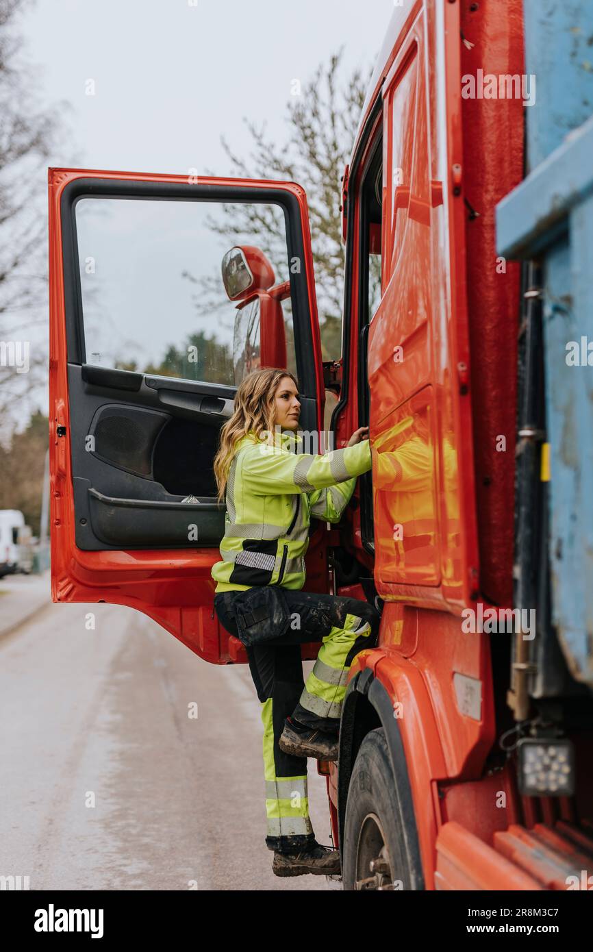 Female construction worker getting into truck Stock Photo - Alamy