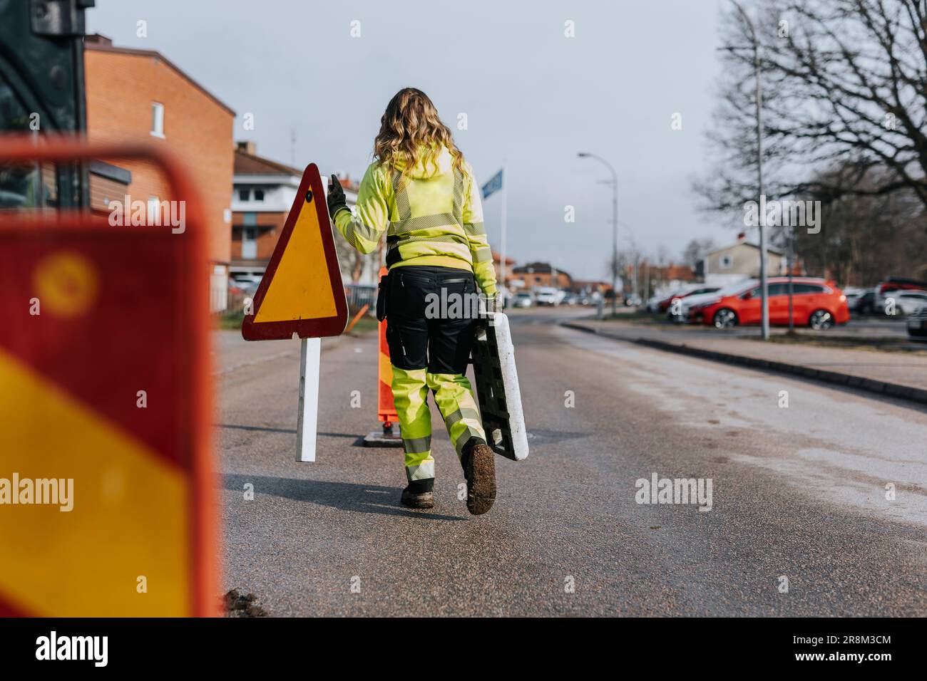 Female road worker carrying road sign Stock Photo - Alamy