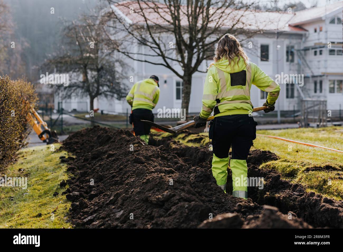 Male and female workers digging trench Stock Photo - Alamy