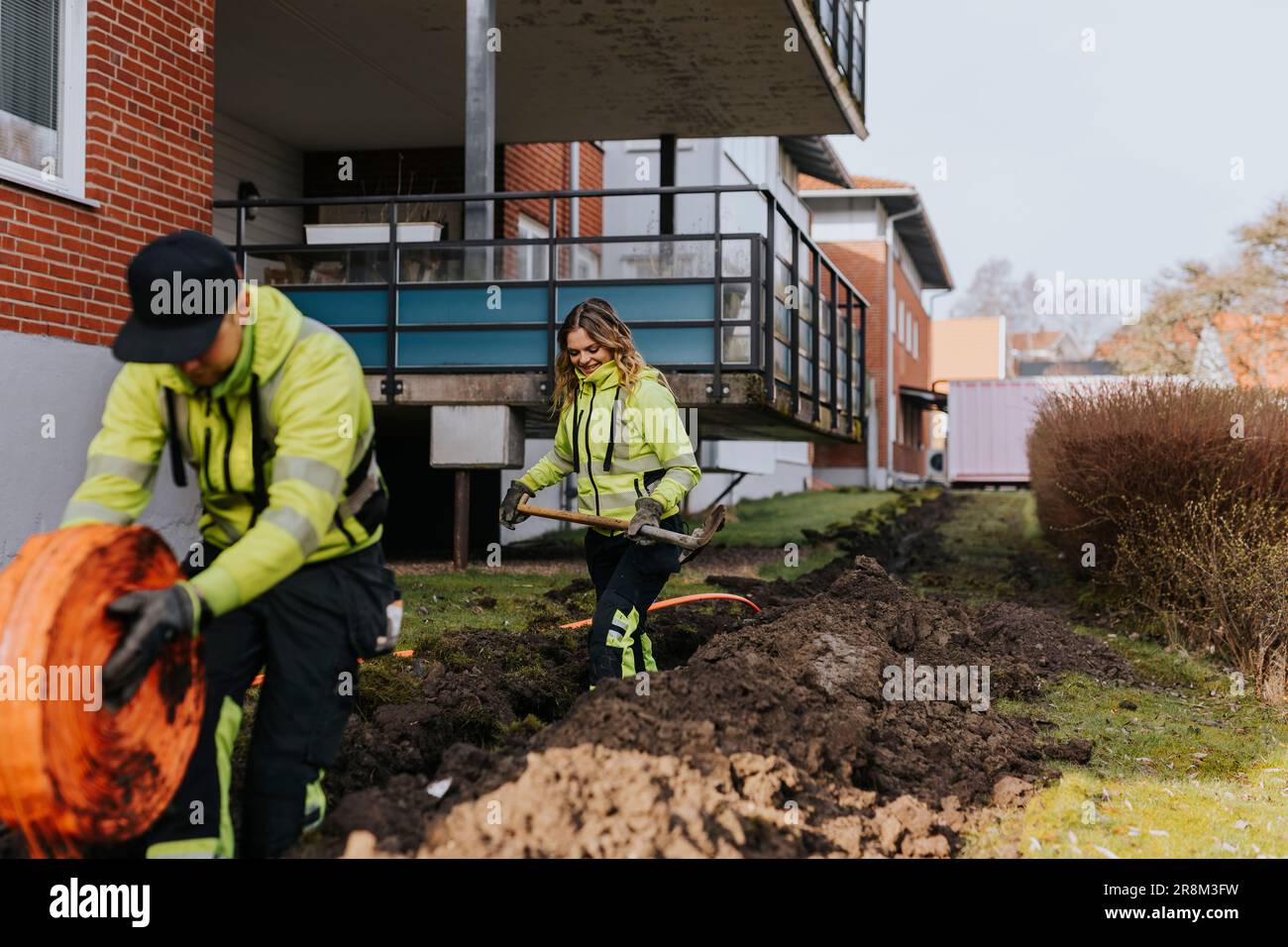 Male and female workers laying cables in trench Stock Photo - Alamy