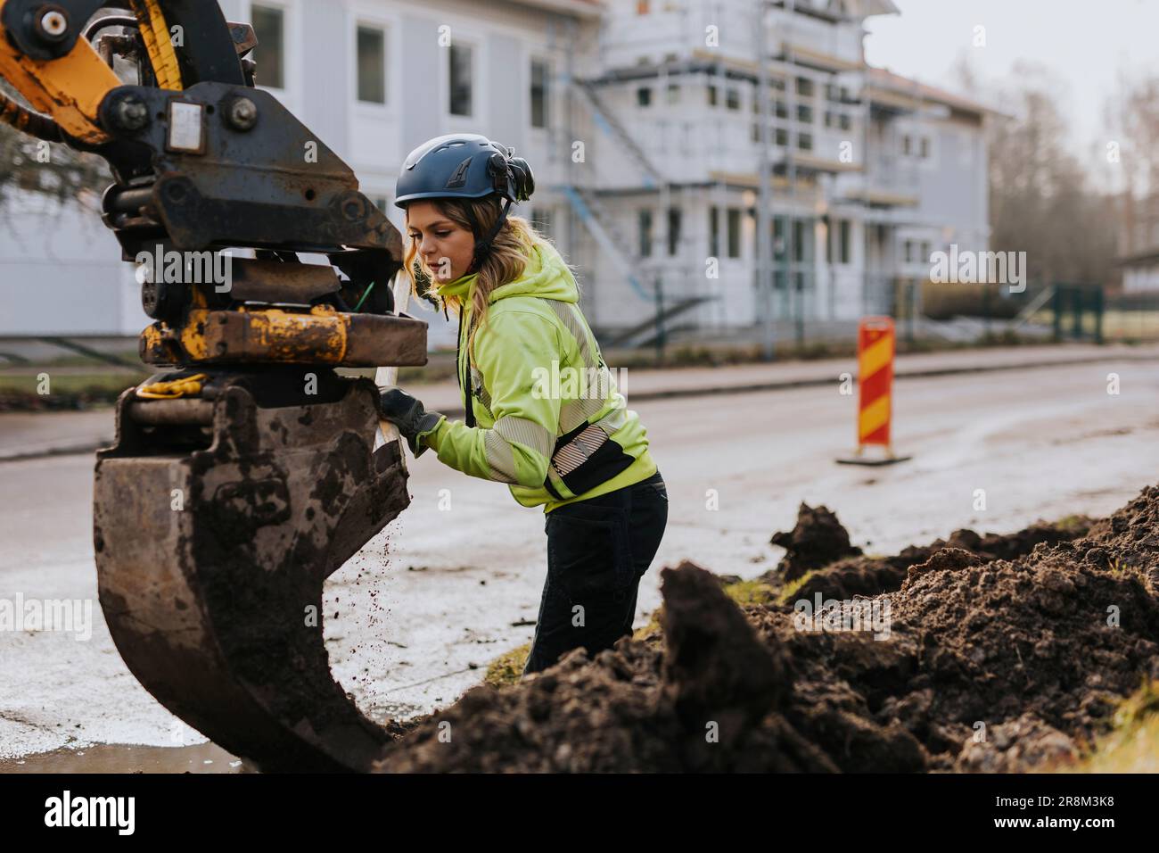 Female road worker and excavator at digging site Stock Photo - Alamy