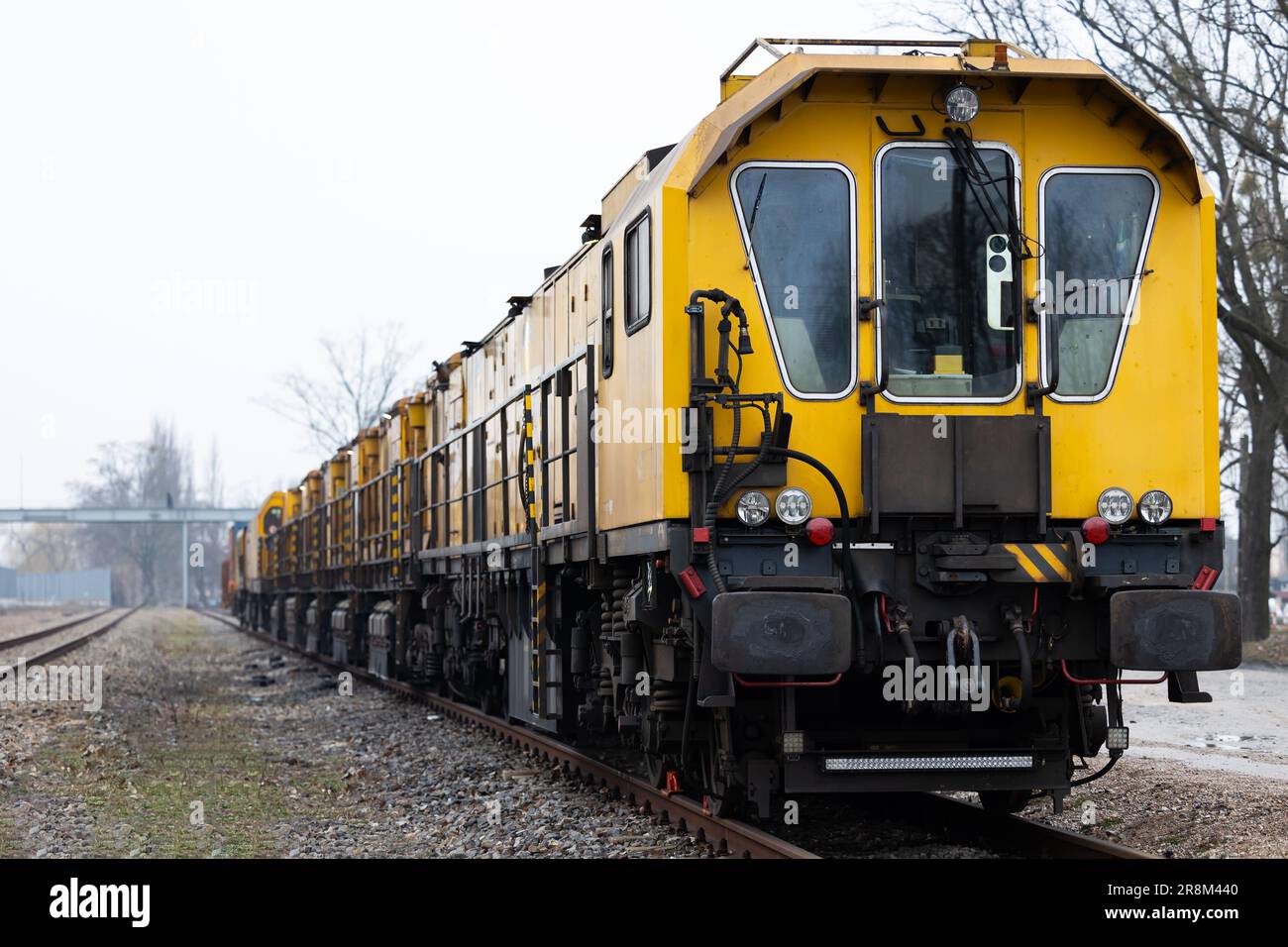 A yellow technical train for grinding rails standing on a railway ...