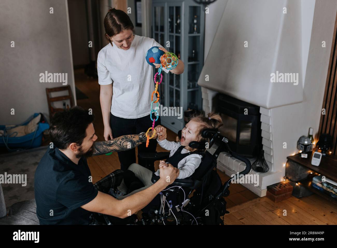 Parents playing with smiling disabled child in wheelchair Stock Photo ...