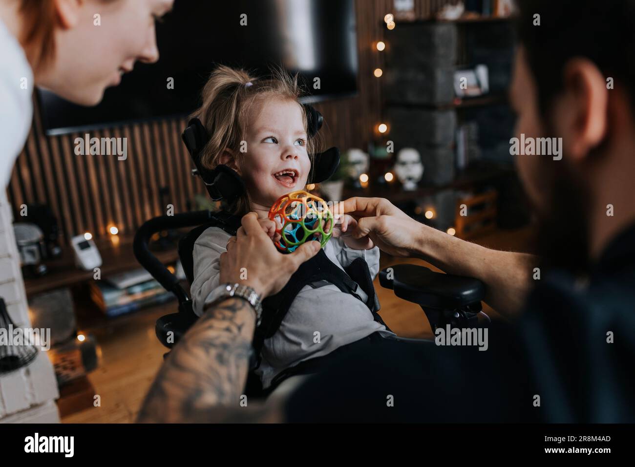 Parents playing with smiling disabled child in wheelchair Stock Photo ...
