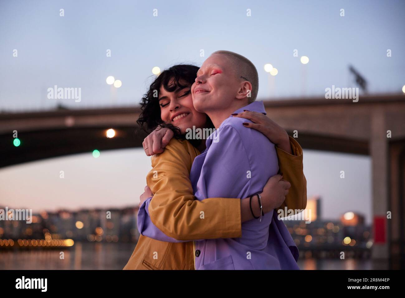 Happy young female friends or gay couple hugging each other Stock Photo ...