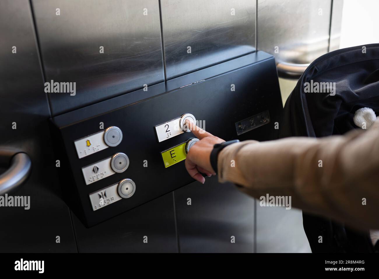 Woman's hand pushing button inside lift Stock Photo - Alamy