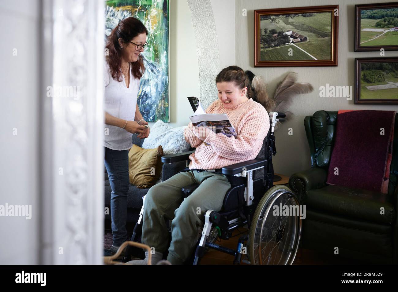Mother With Disabled Daughter In Wheelchair In Living Room Teenage