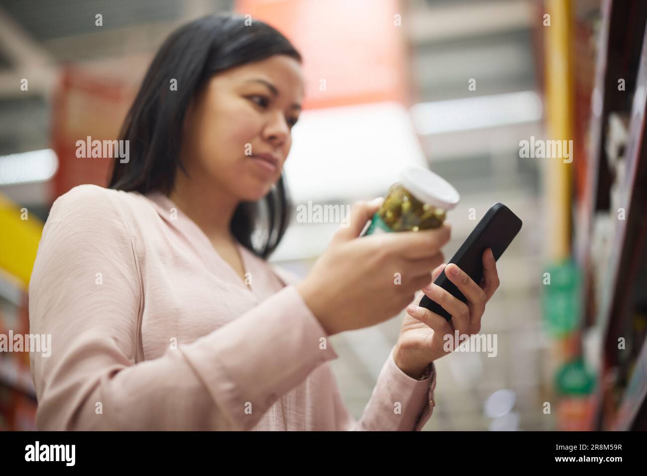 Woman looking at prices during inflation while doing shopping in ...