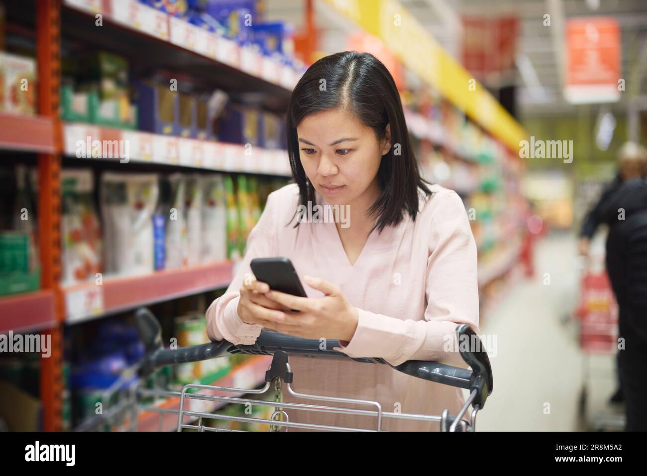 Woman looking at prices during inflation while doing shopping in ...